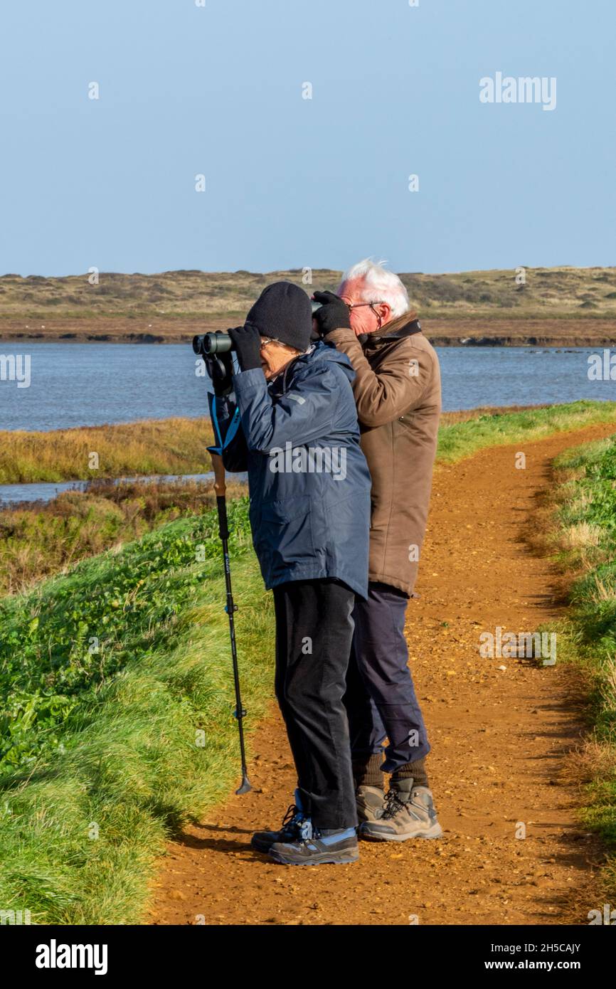 older couple birdwatching together on the norfolk coast at burnham ...