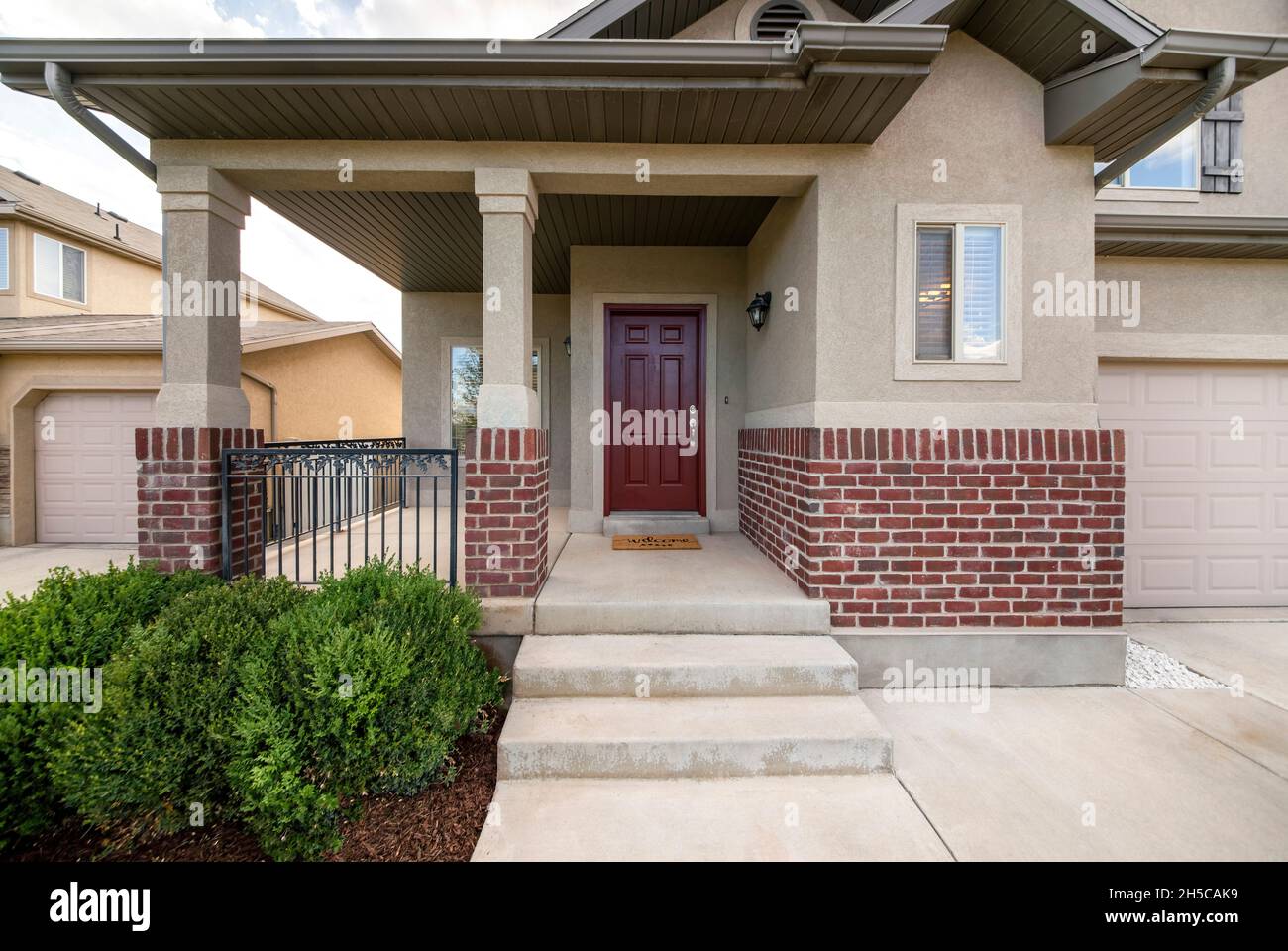 Facade of a house with bricks and burgundy front door Stock Photo - Alamy
