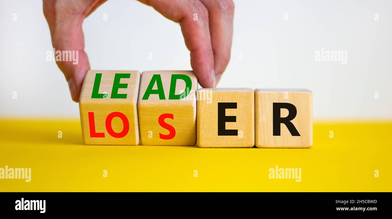Loser or leader symbol. Businessman turns cubes and changes the word ...