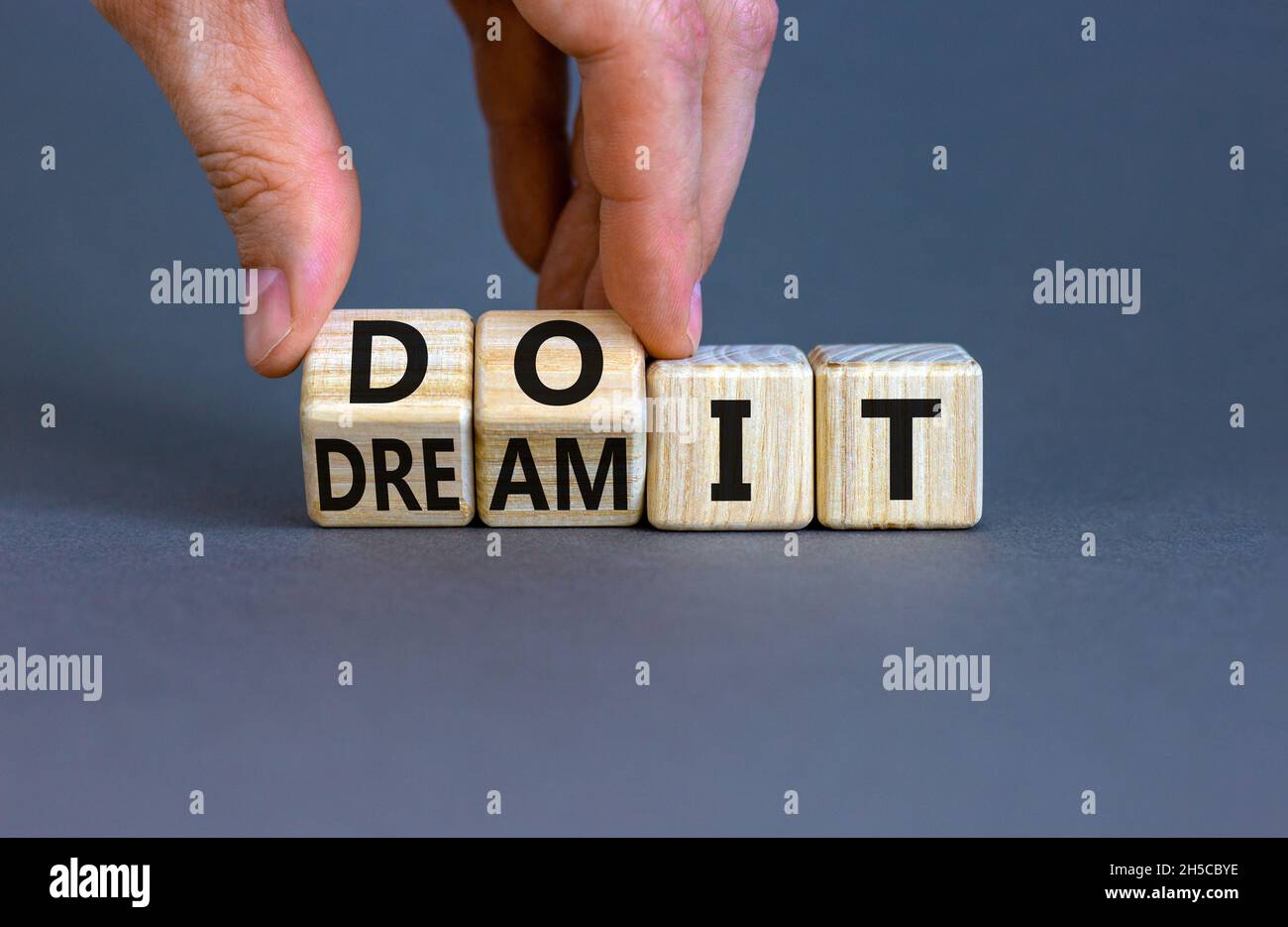 Dream and do it symbol. Businessman turns cubes and changes words ...