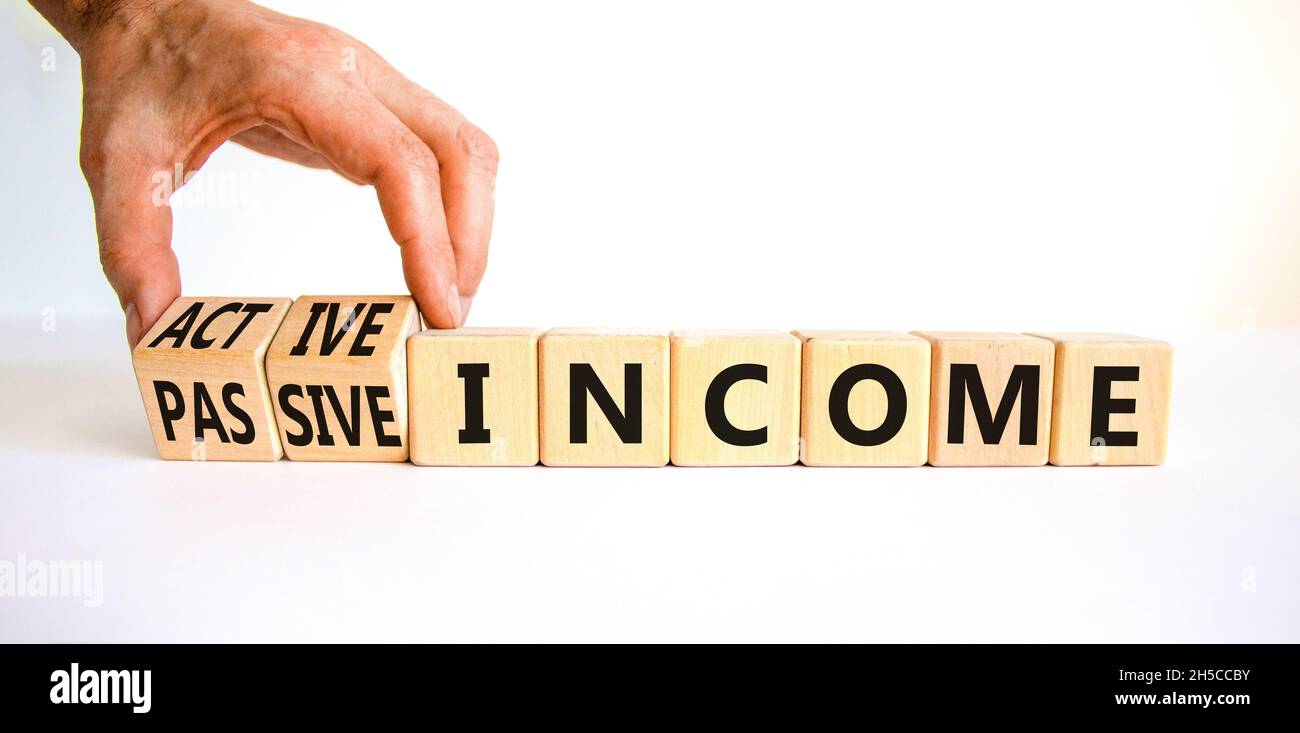 Passive or active income symbol. Businessman turns wooden cubes and ...