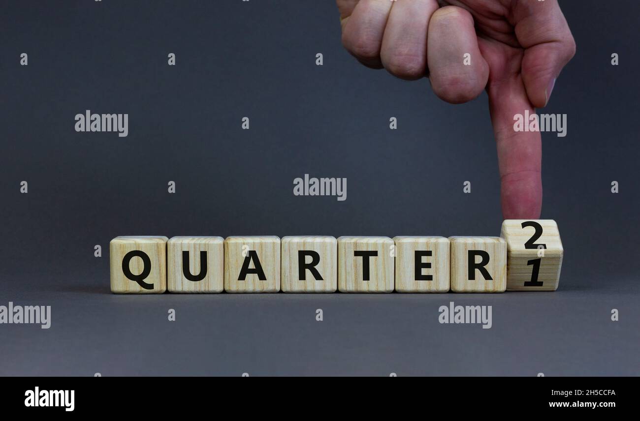 From 1st to 2nd quarter symbol. Businessman turns a cube and changes ...