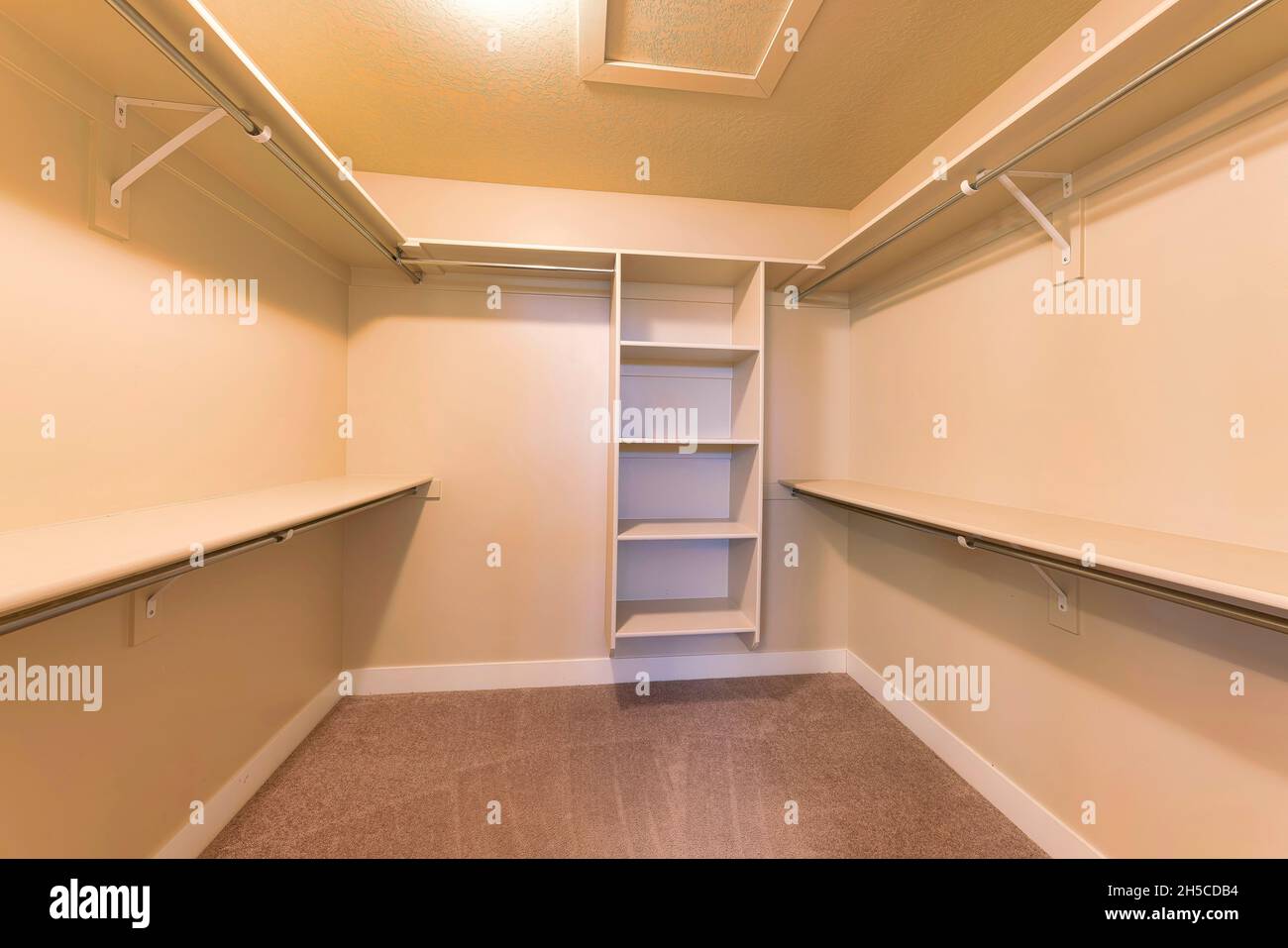 Empty walk-in closet with warm color lighting and shelving units Stock ...