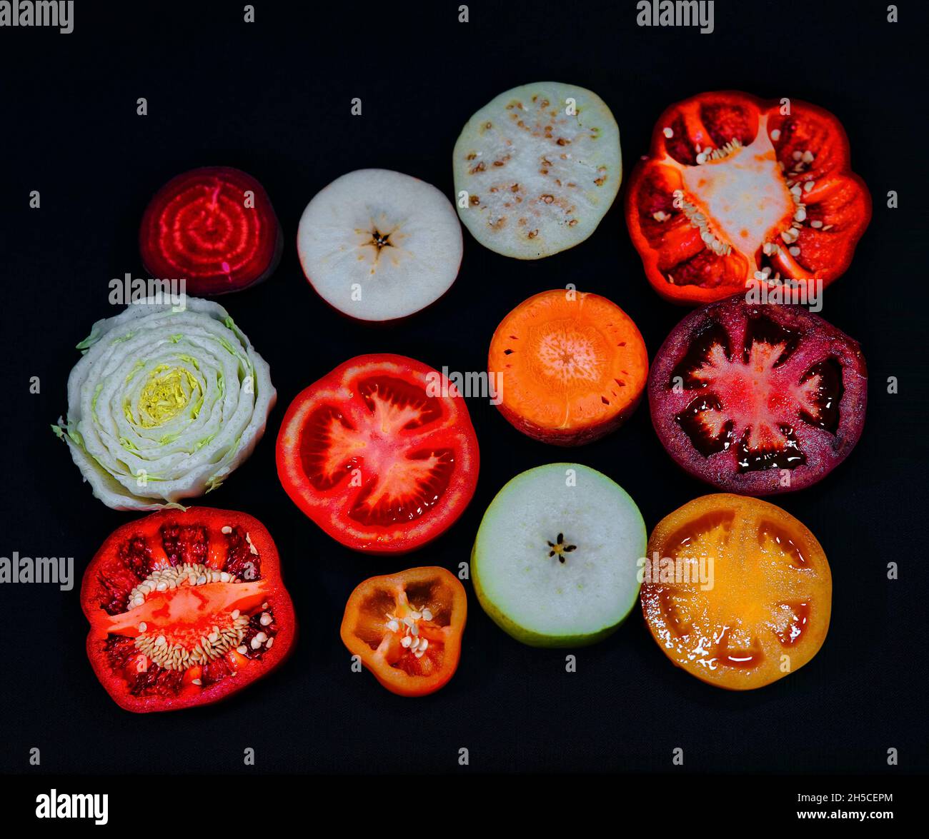 Top view of cut in a half vegetables and fruits isolated a black ...