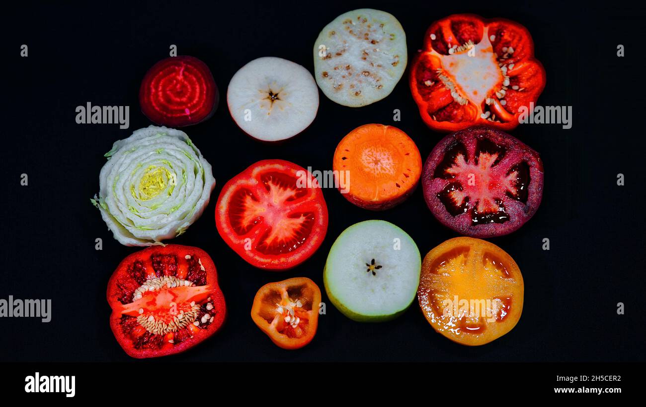 Top view of cut in a half vegetables and fruits isolated a black ...