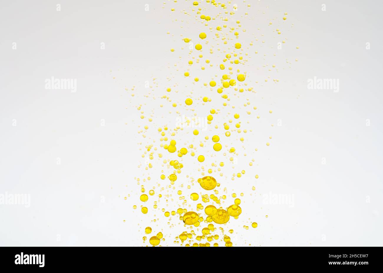 Oil drops isolated. Golden liquid drops of oil in water on a white ...