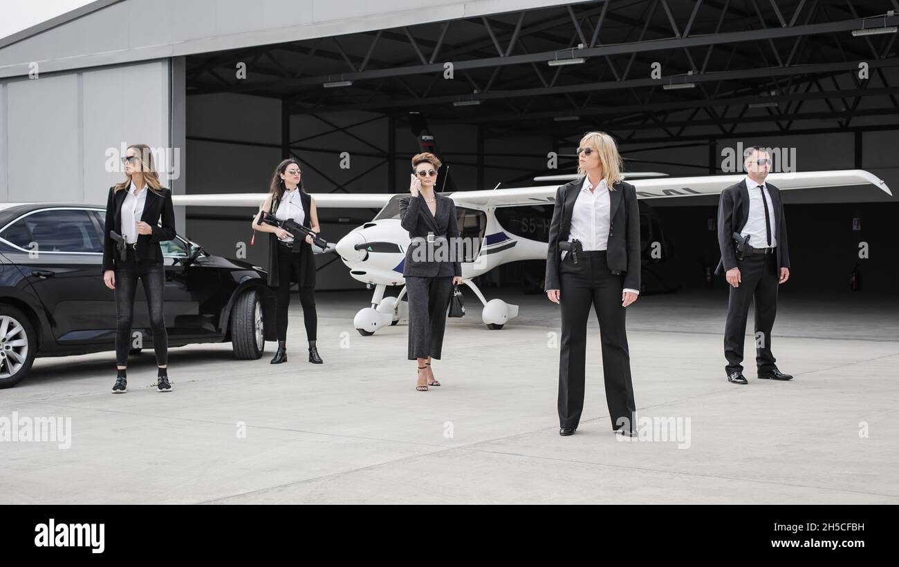 Professional team of female and male bodyguards protect famous VIP ...