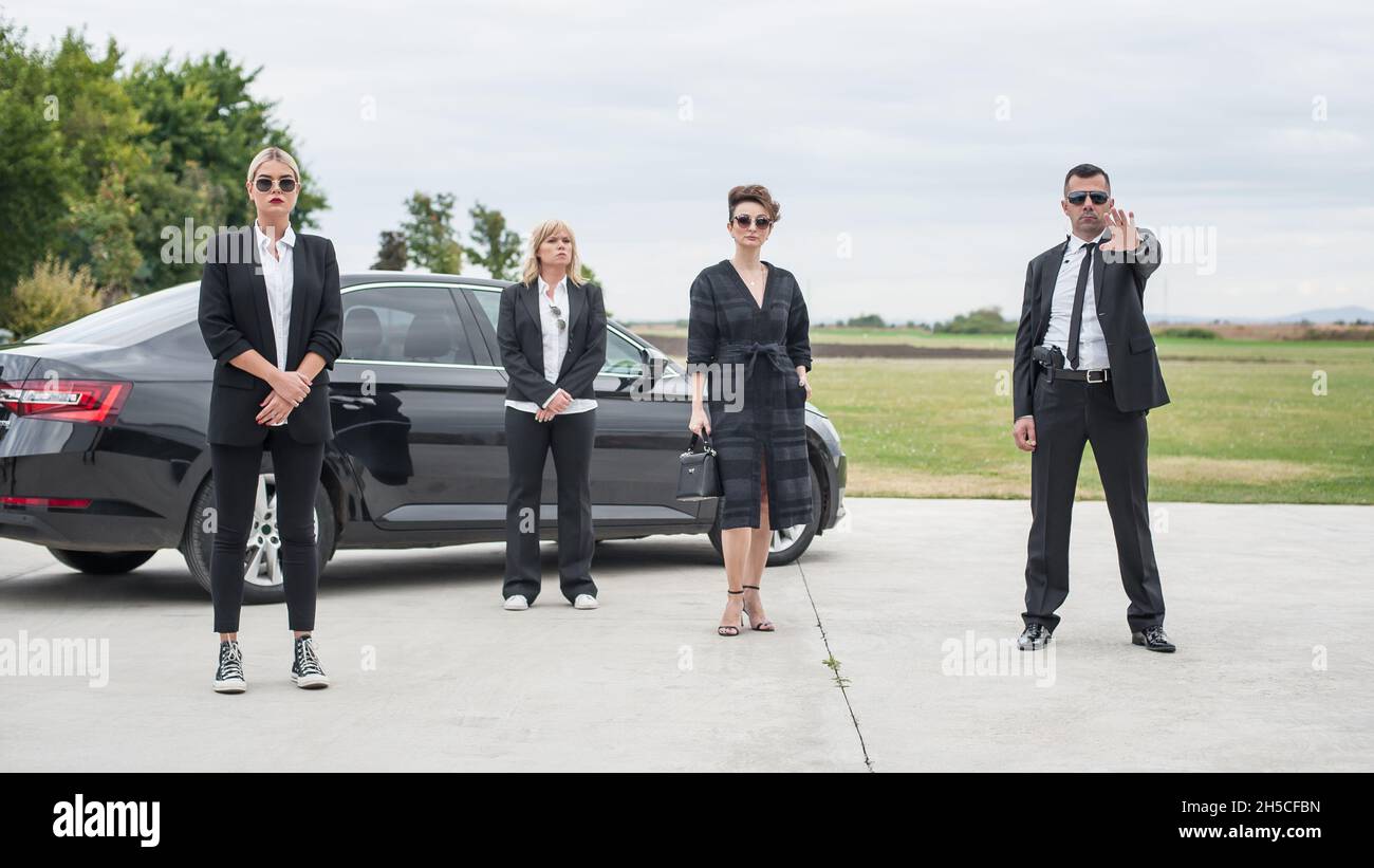 Professional team of female and male bodyguards protect famous VIP ...
