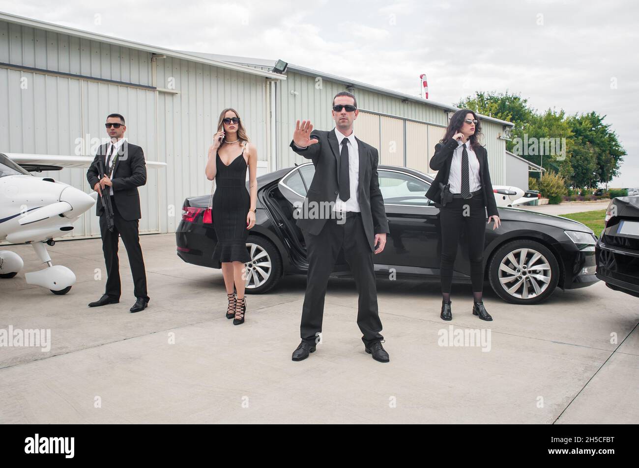 Professional team of female and male bodyguards protect famous VIP ...