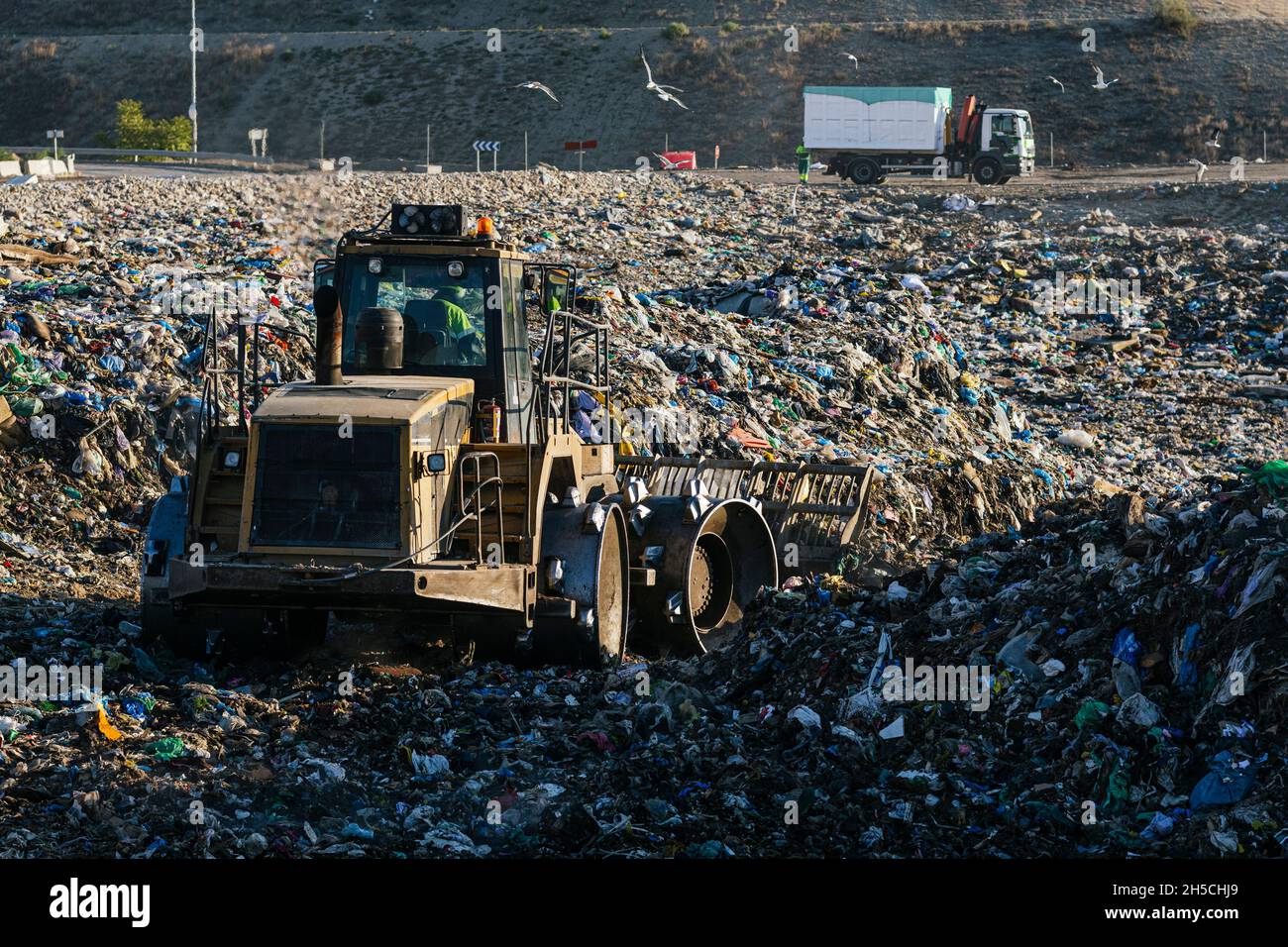 Excavator sorting metals for recycling at a recycling center, vertical ...