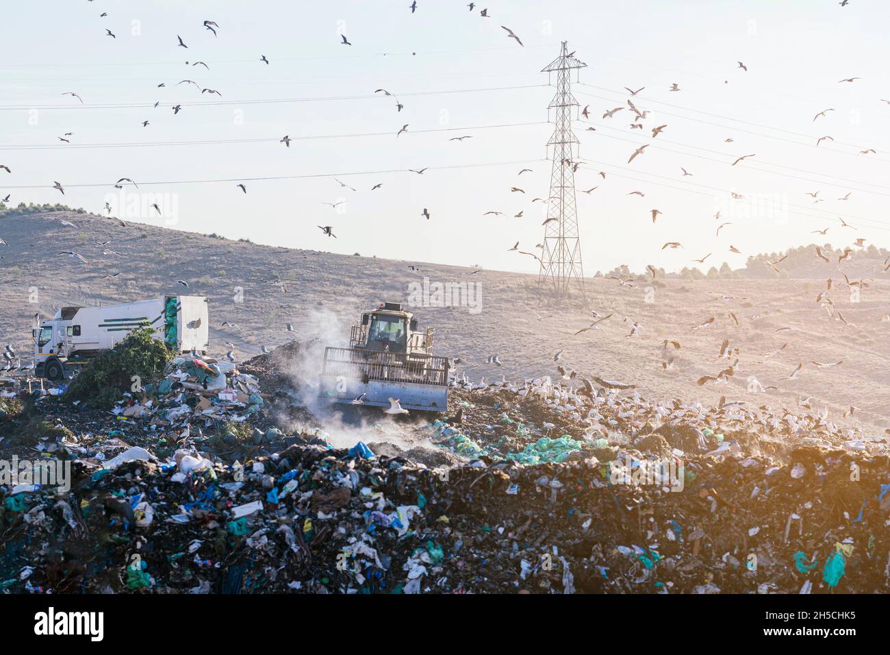 Excavator sorting metals for recycling at a recycling center, vertical ...