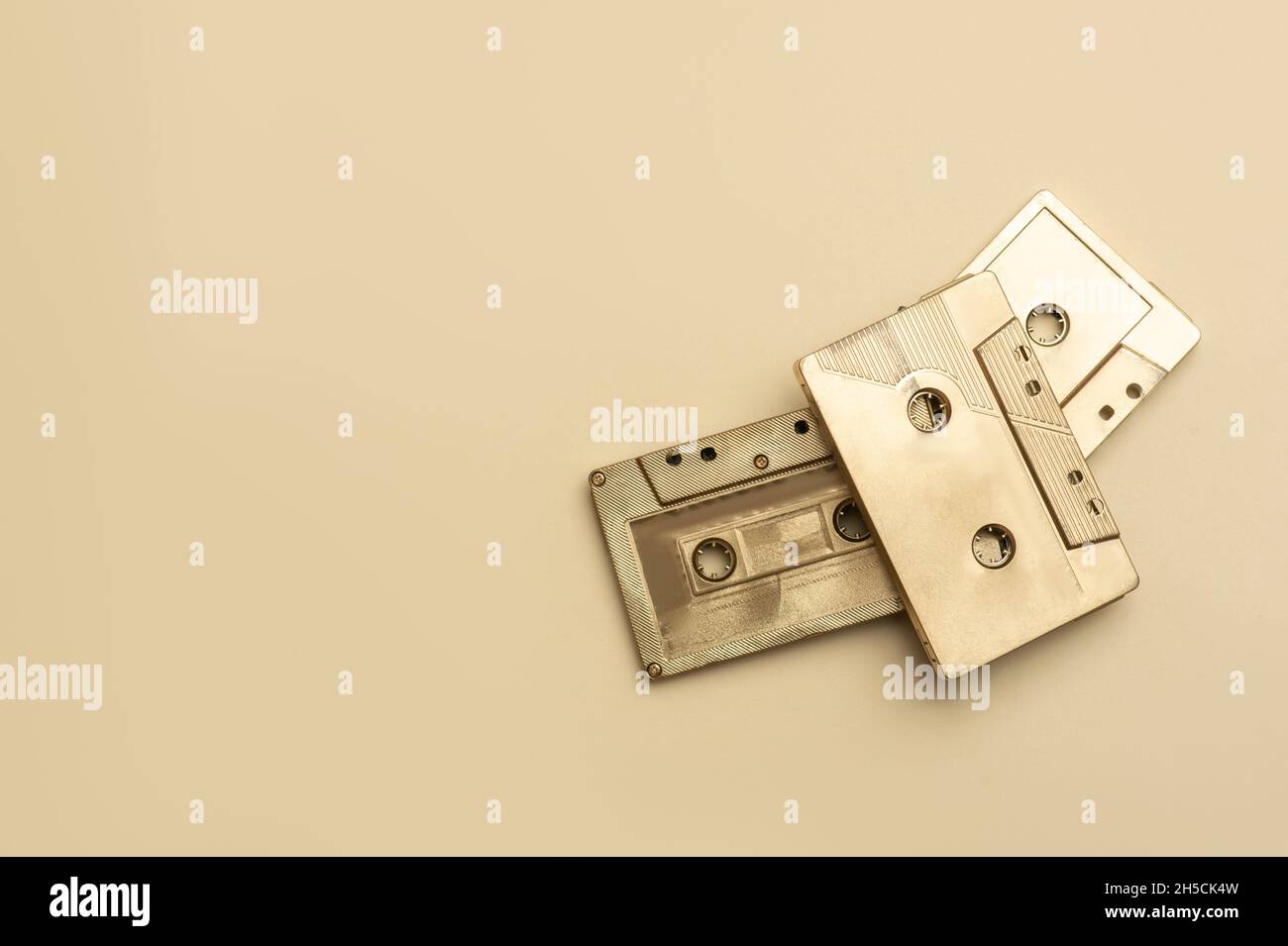 Gold fancy retro old audio cassettes tape on beige color background ...