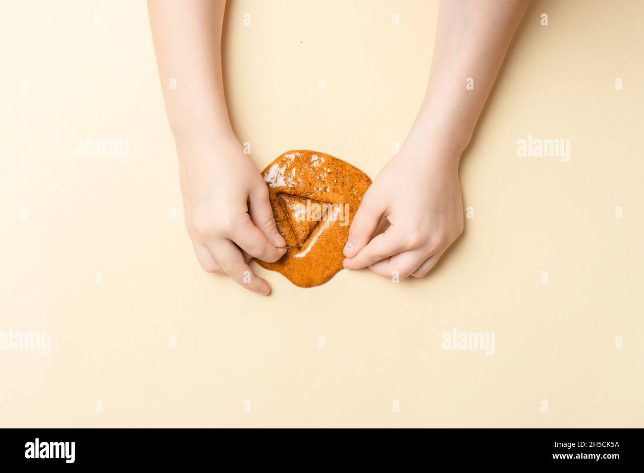 Korean dalgona honeycomb sugar cookie with triangle shapes .Hands play ...