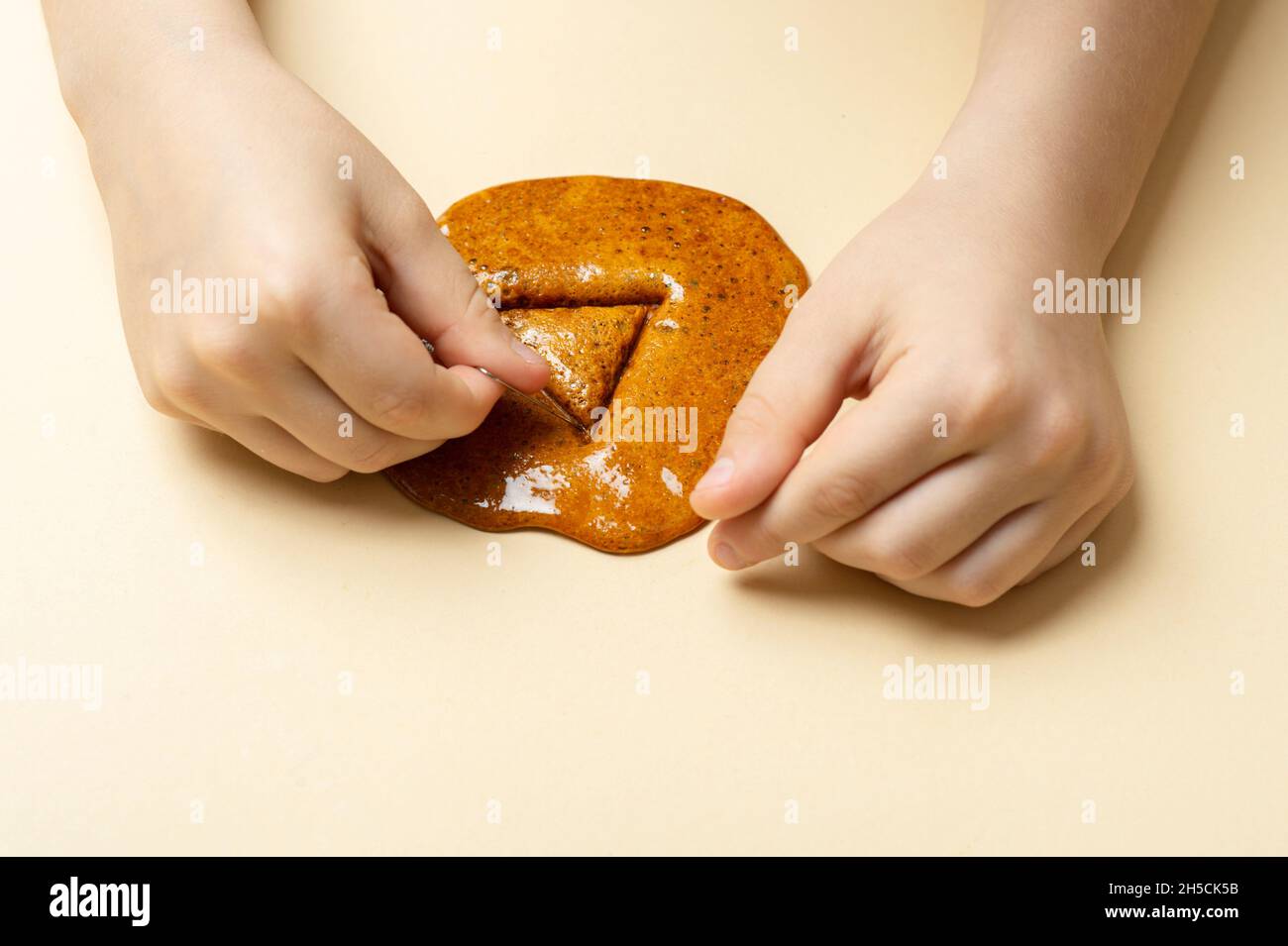 Korean dalgona honeycomb sugar cookie with triangle shapes .Hands play ...