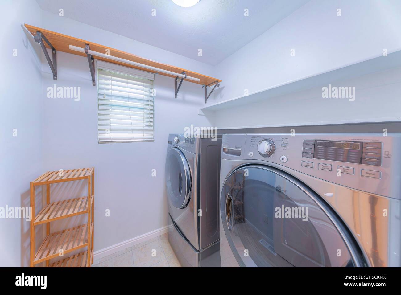 Small white laundry room interior with wooden shelves and floor rack ...