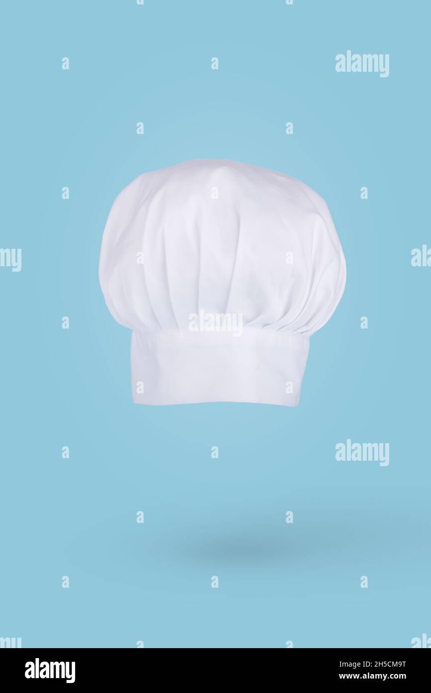 Chef hat floating in air isolated on a blue background. Creative ...