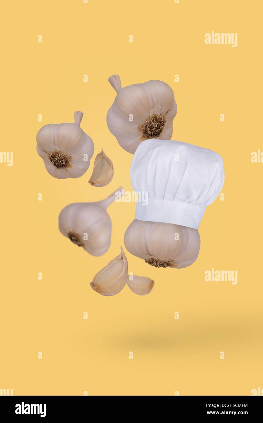 Fresh garlic flying in air isolated on yellow background. Healthy food ...