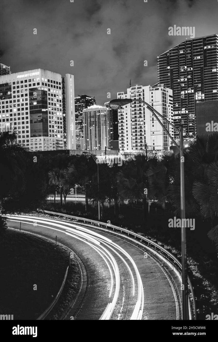 Grayscale of a road and high buildings behind withtime-lapse effect ...