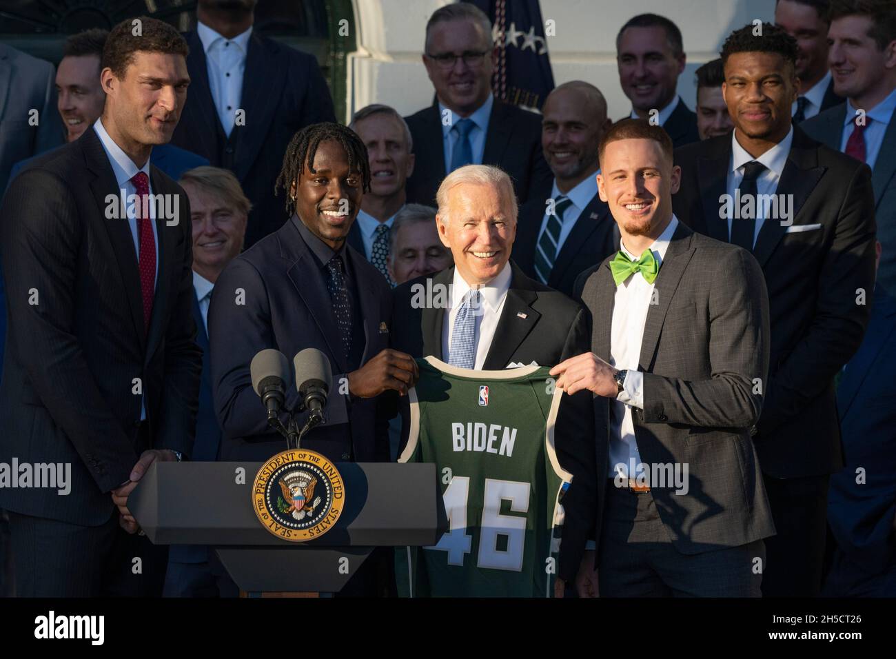 United States President Joe Biden receives a team jersey from members ...