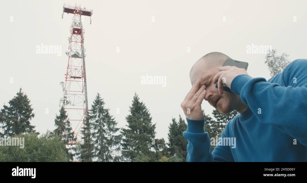 4G and 5G cellular radio tower, the man has a bad headache Stock Photo ...