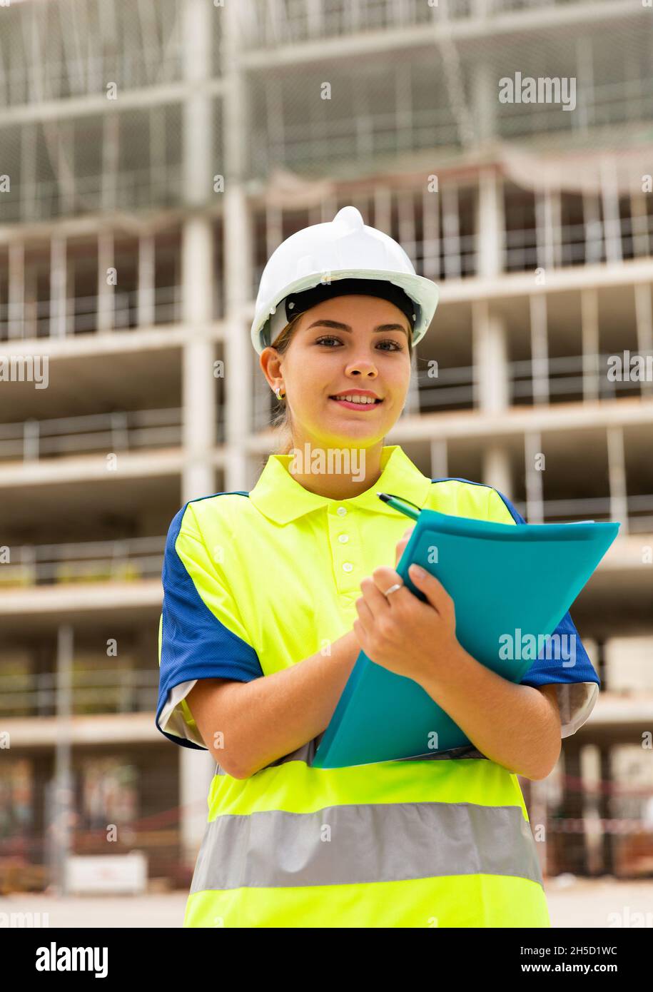 Portrait of a young confident female process engineer writing work ...