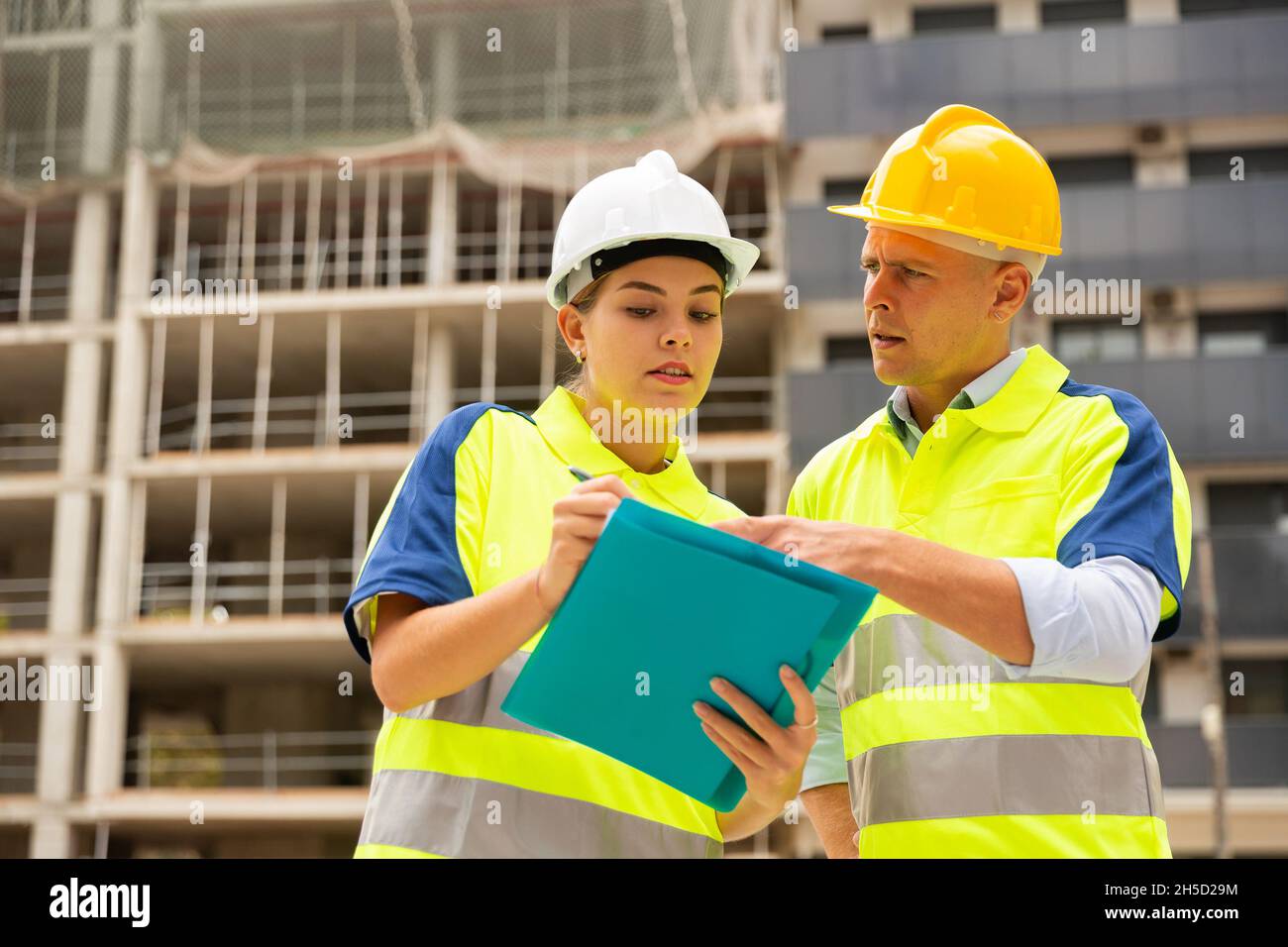 Civil engineers checking work process in construction site Stock Photo ...
