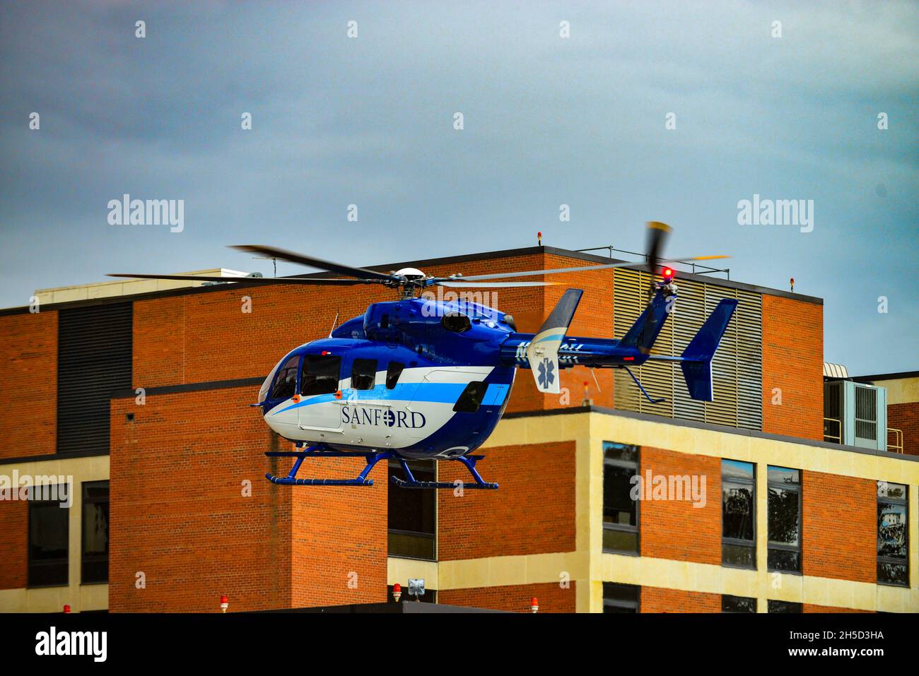 Medical helicopter in flight departing hospital Stock Photo - Alamy
