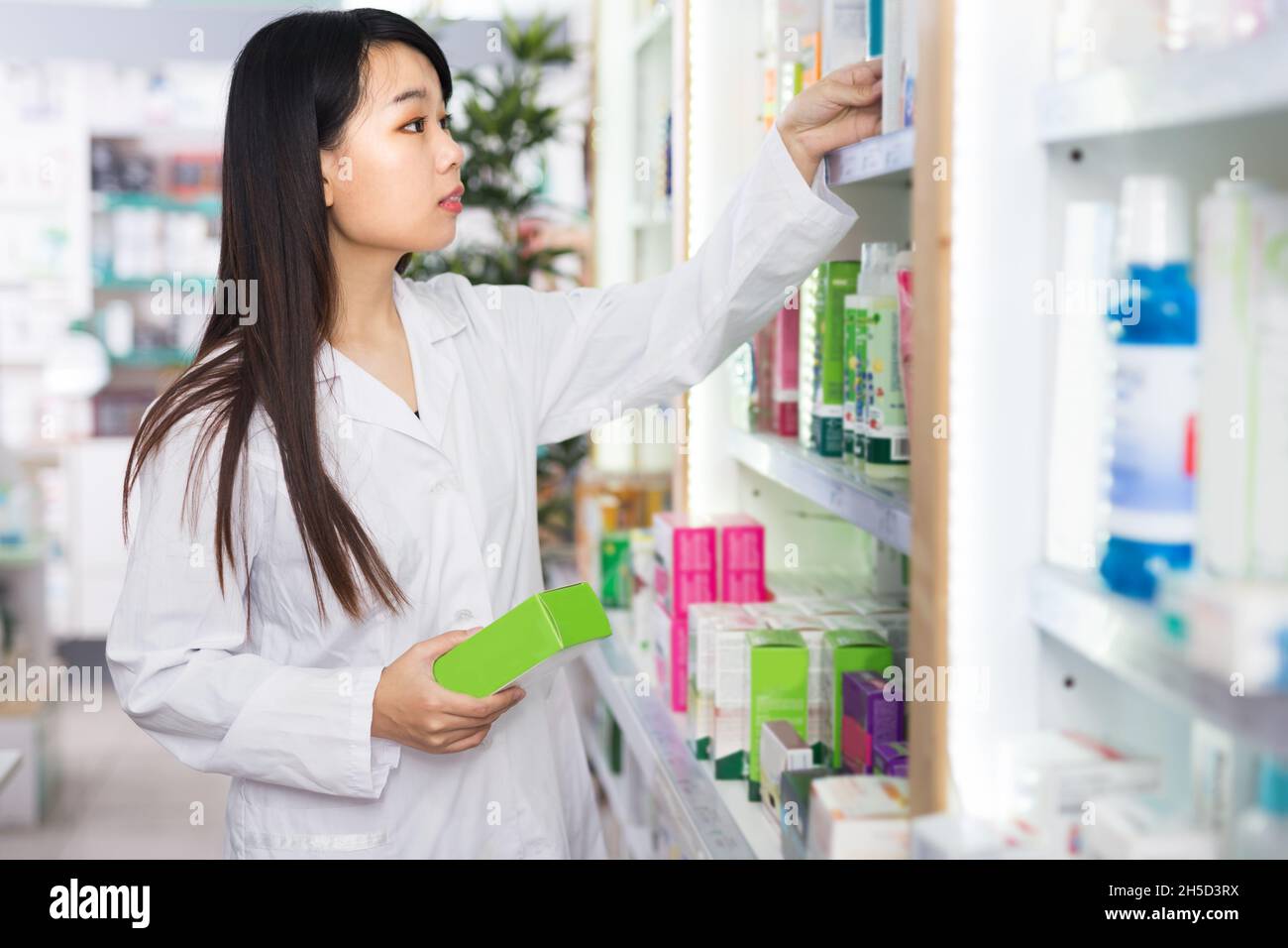 Chinese female pharmacist standing in pharmacy Stock Photo - Alamy