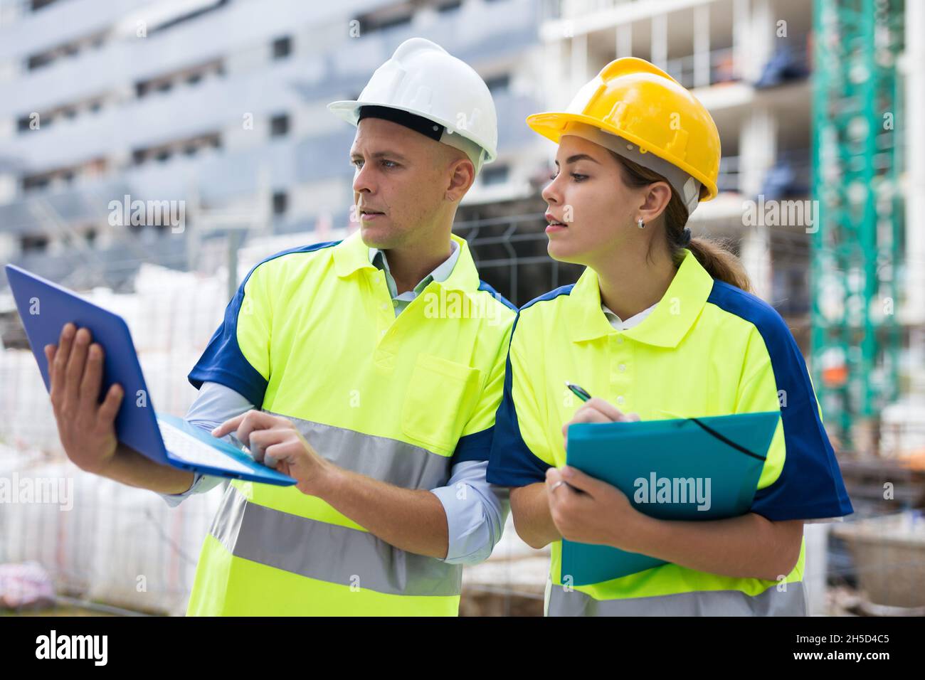 Two builders planning their work in construction plant Stock Photo - Alamy