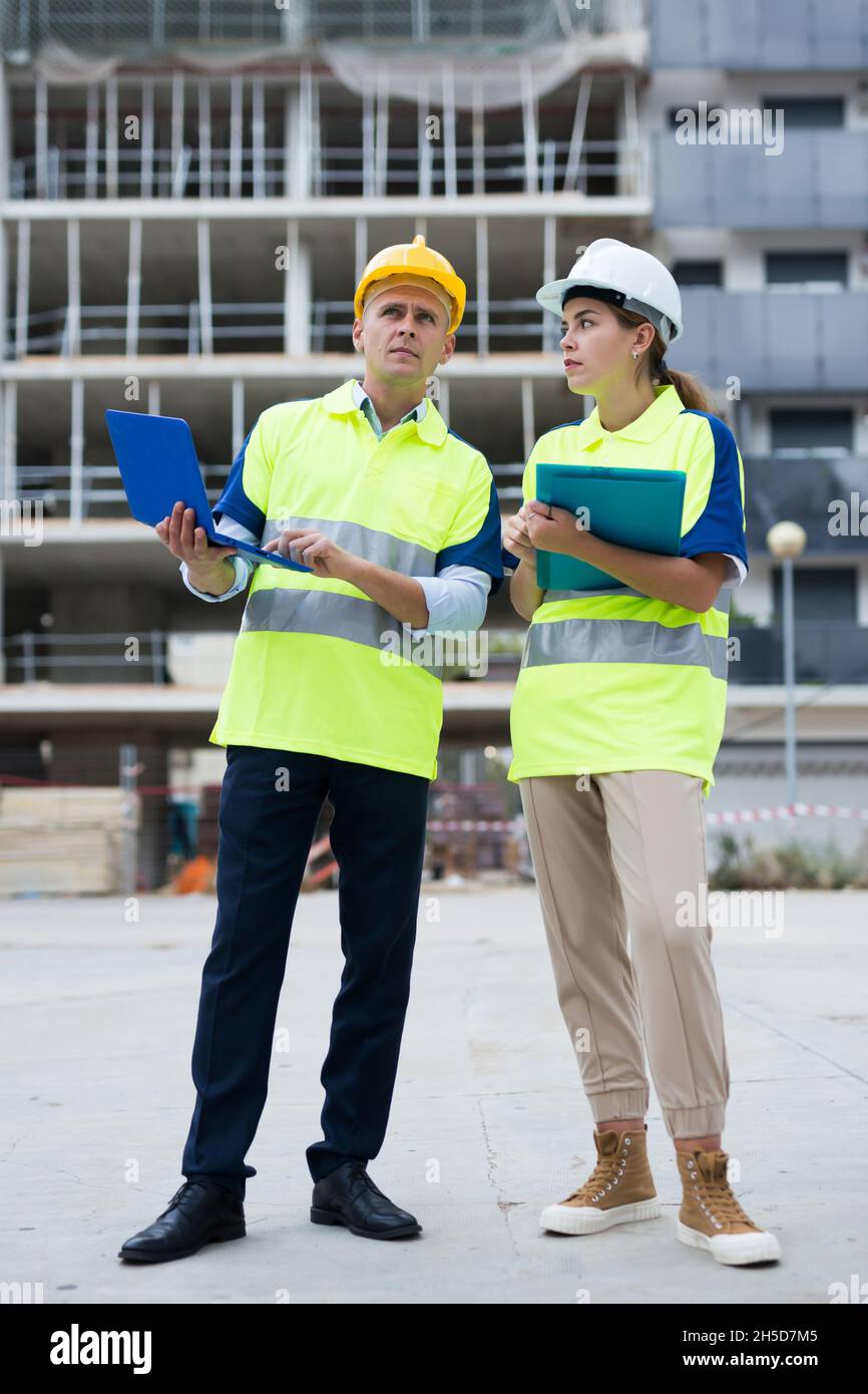 Two builders planning their work in construction plant Stock Photo - Alamy