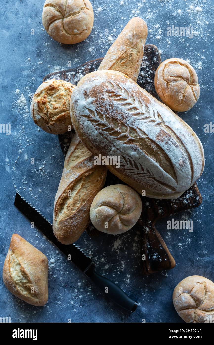 Top down view of various sourdough bread and buns against a dark ...