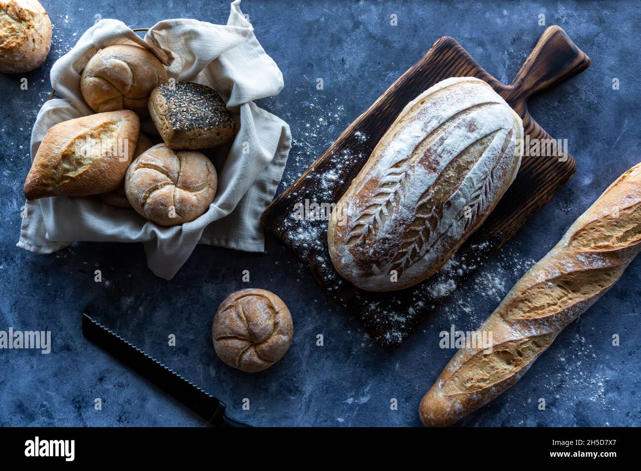 Top down view of various sourdough bread and buns, against a dark ...