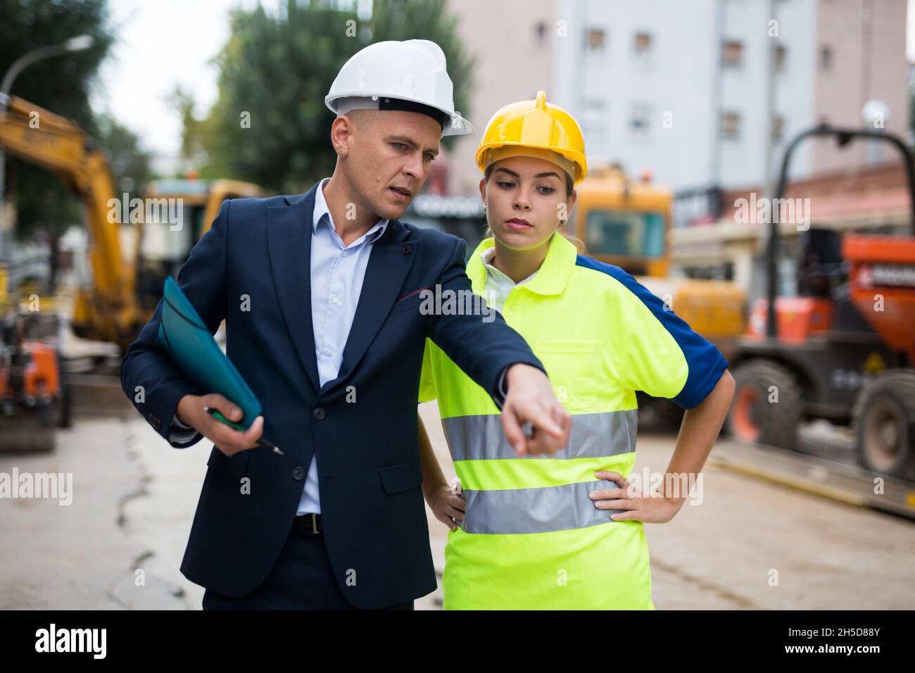 Civil engineers checking work process in construction site Stock Photo ...