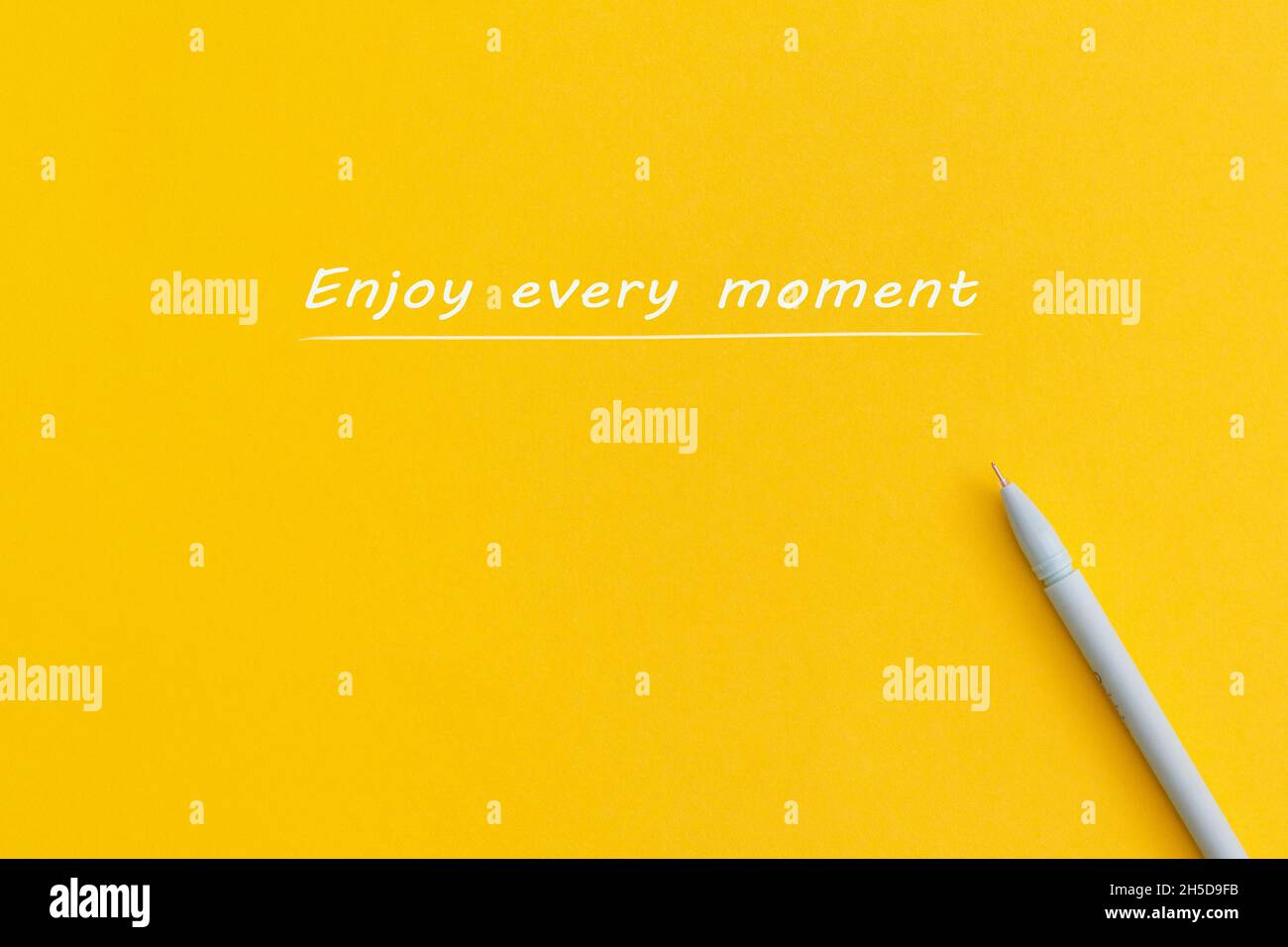 The text "Enjoy every moment" on yellow background Stock Photo - Alamy