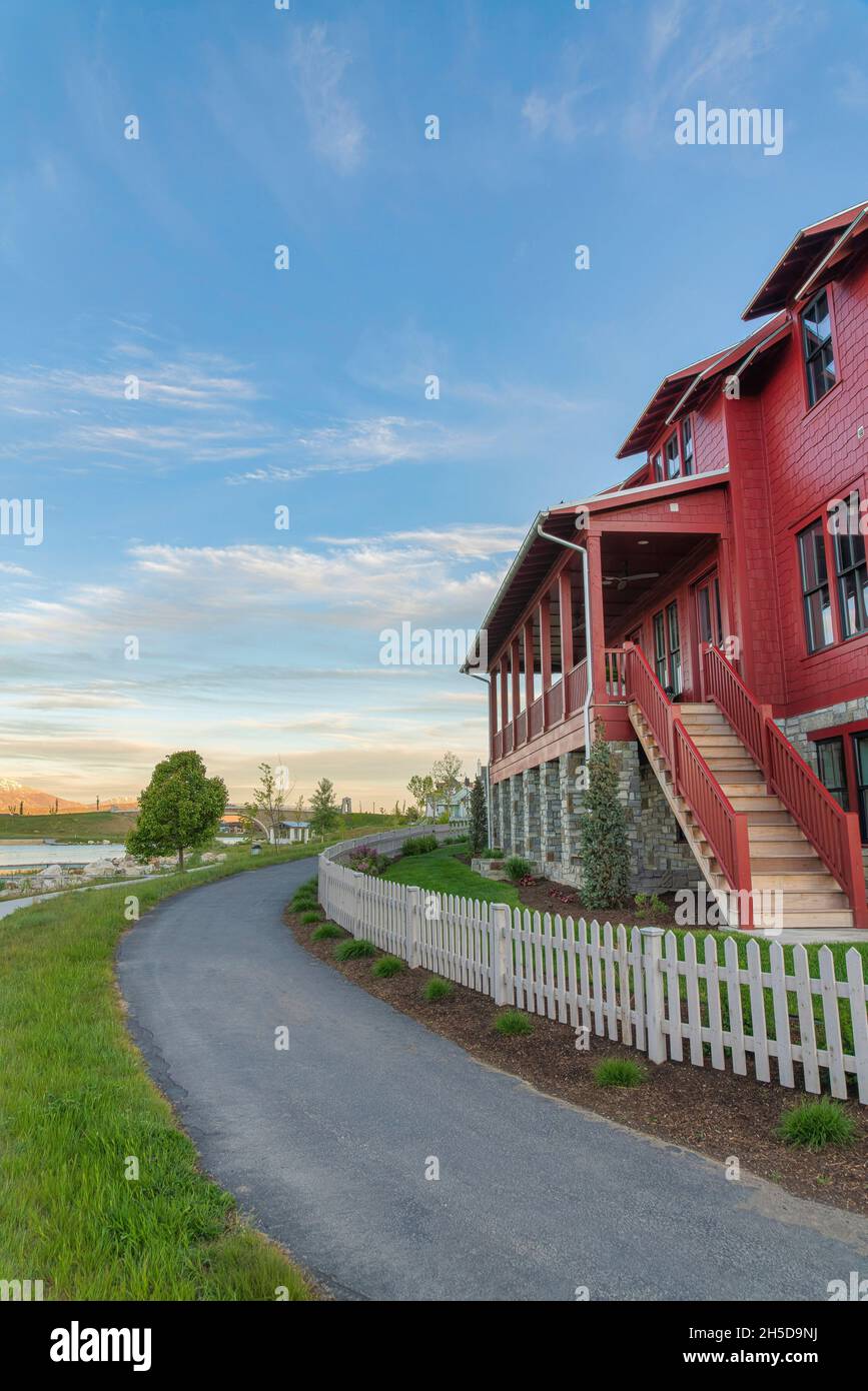 Curved asphalt pathway at the front of a fenced house at Daybreak, Utah ...