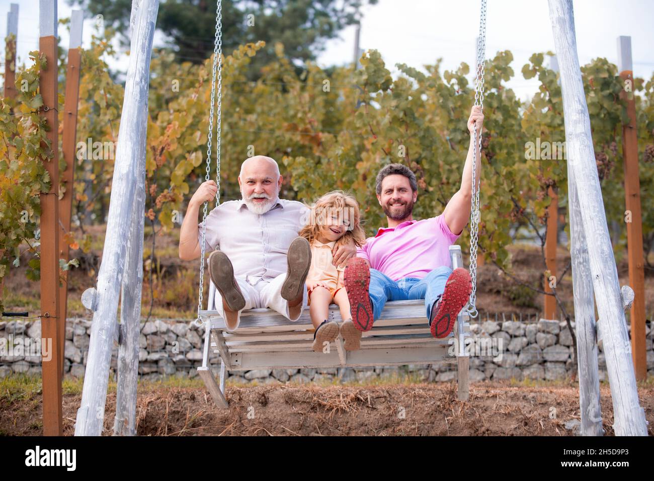 Men generation family playing on swing together Excited grandfather ...