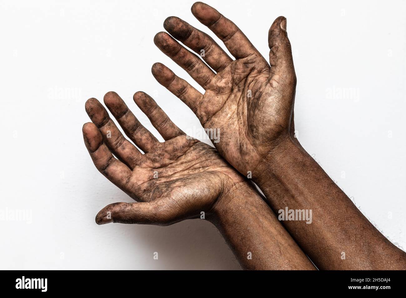 Hands of a worker doing manual work dirty with grease and dust isolated ...