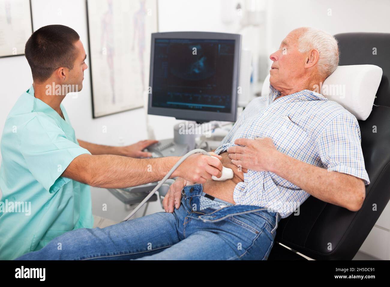 Doctor pointing to monitor during examination a man with ultrasound ...