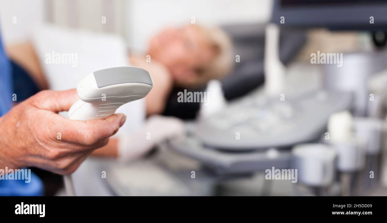 Male doctor holding ultrasonic probe in hand, ultrasound machine and ...