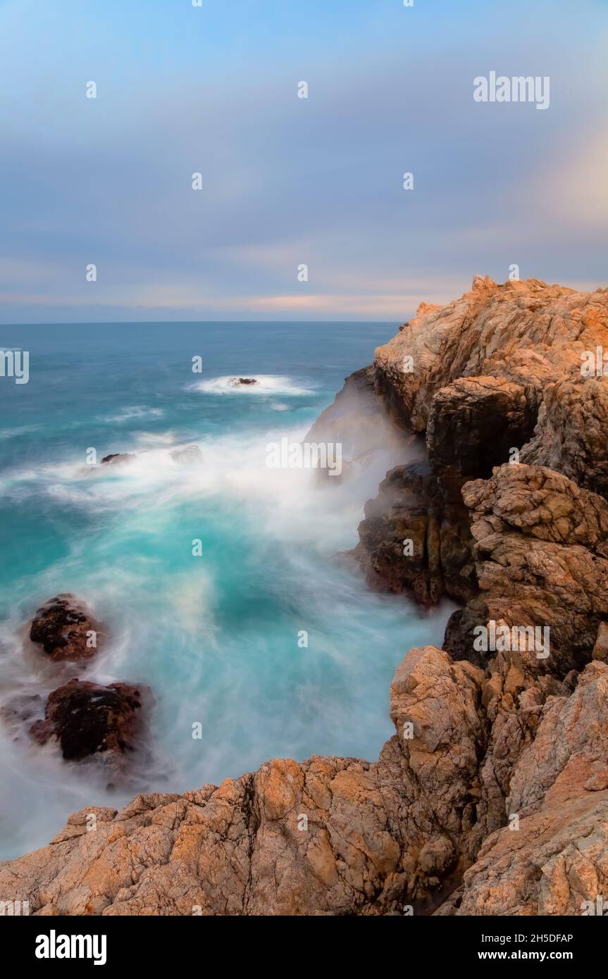 The image captures a breathtaking view of a rugged coastline bathed in ...