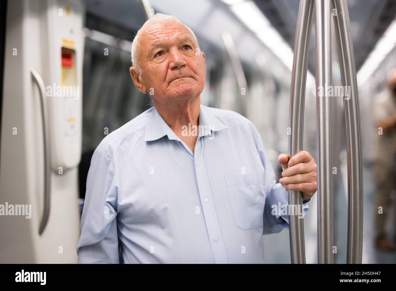 Old man standing in subway car Stock Photo - Alamy