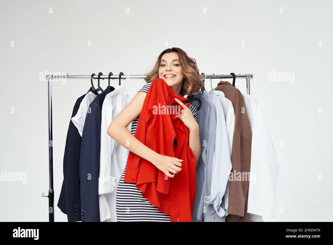 emotional woman selection of clothes near the wardrobe light background ...