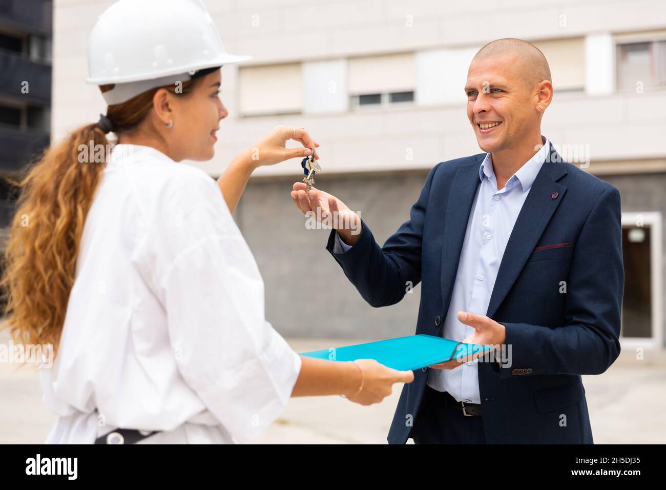 Real estate manager giving keys to man Stock Photo - Alamy