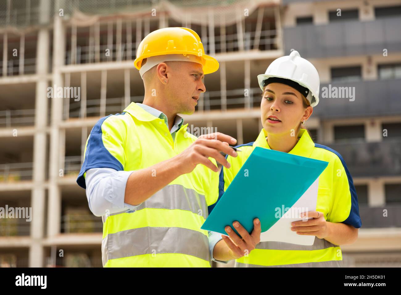 Civil engineers checking work process in construction site Stock Photo ...