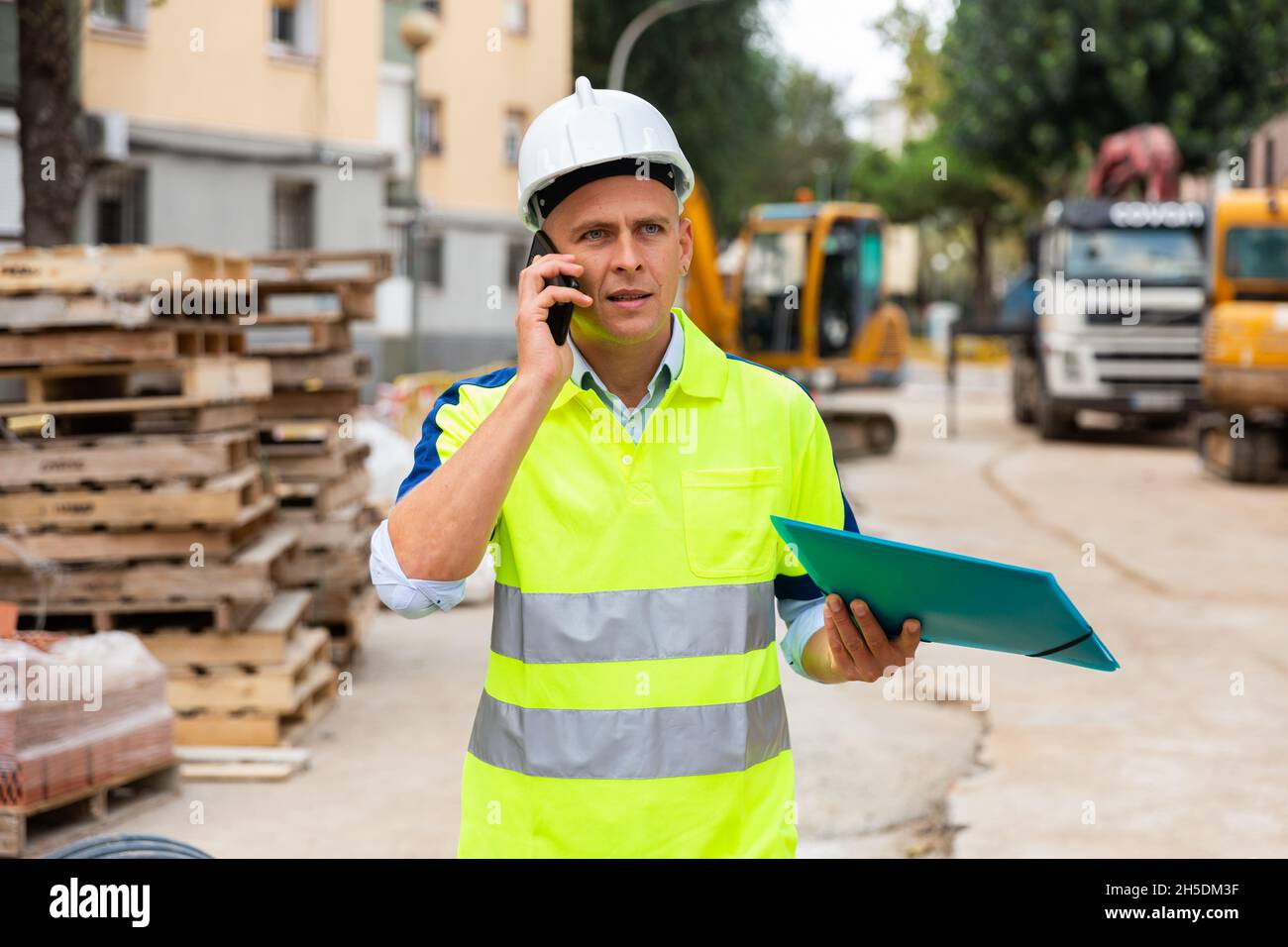 Engineer having telephone conversation in construction area Stock Photo ...