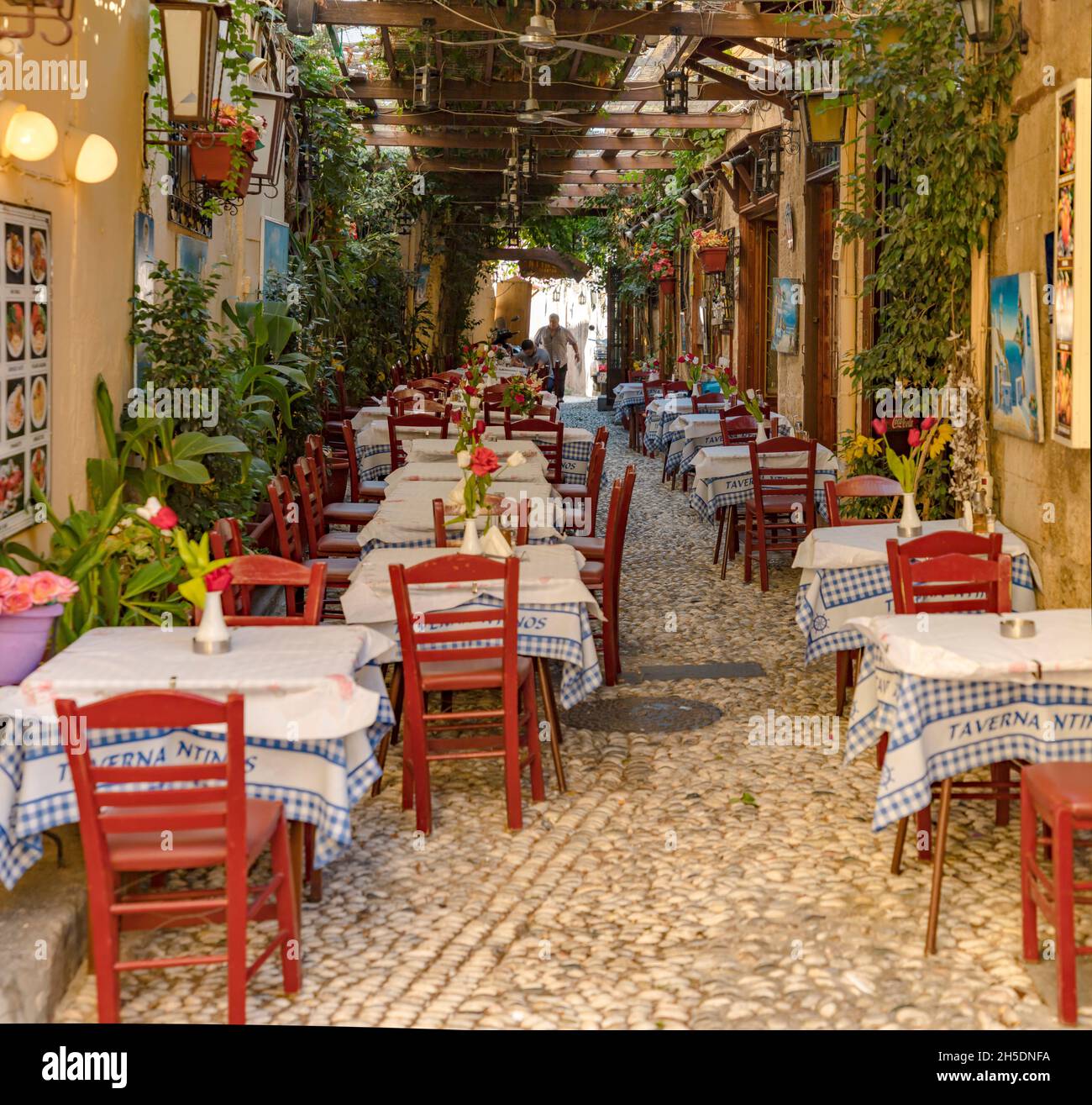Restaurant tables in an alley *** Local Caption *** Rhodes city, Rhodos ...