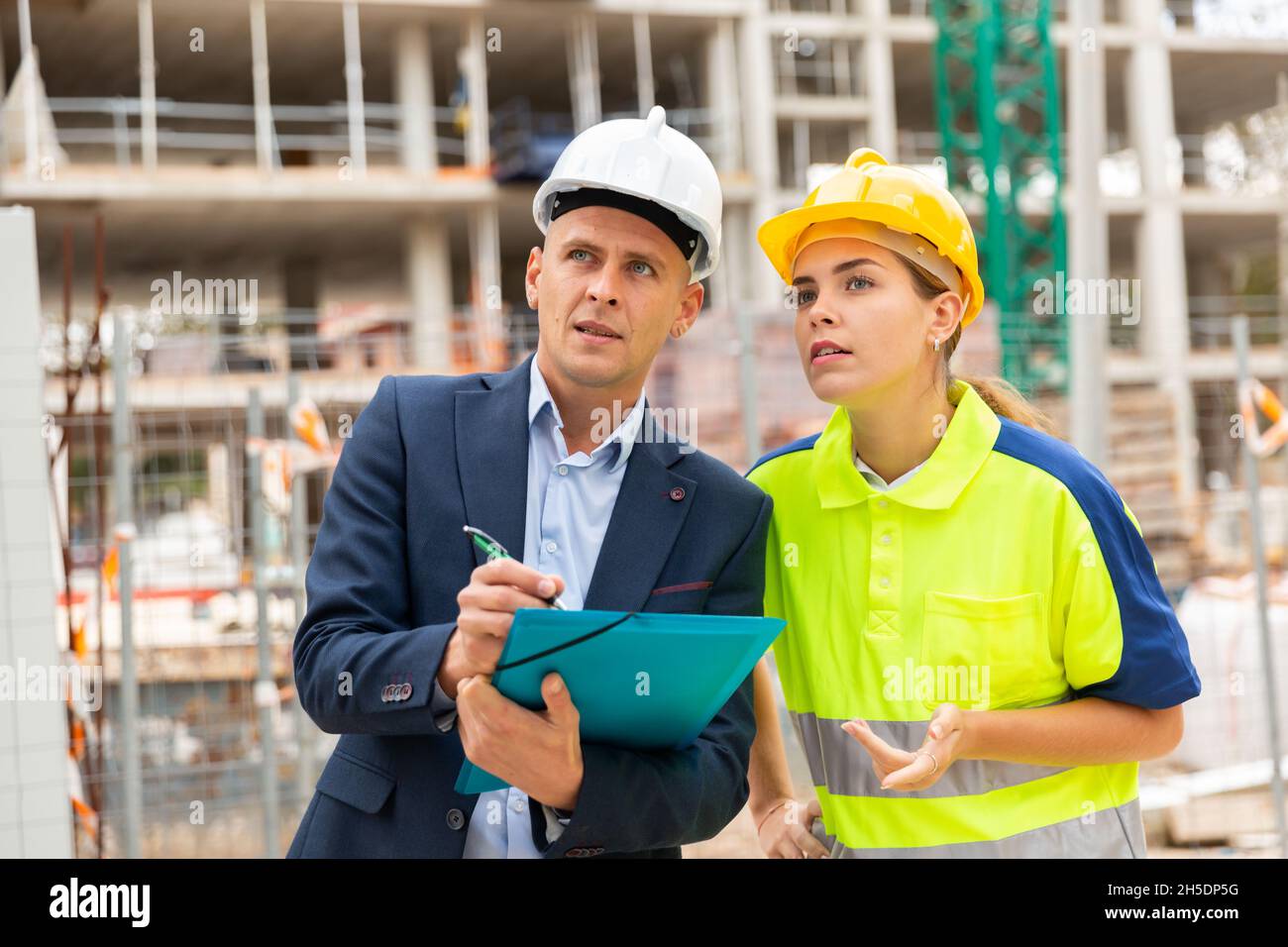 Man and woman engineers in construction site Stock Photo - Alamy