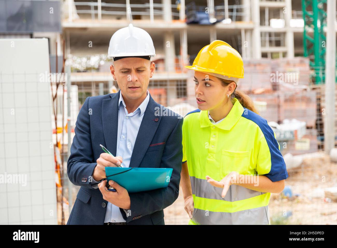 Man and woman engineers in construction site Stock Photo - Alamy