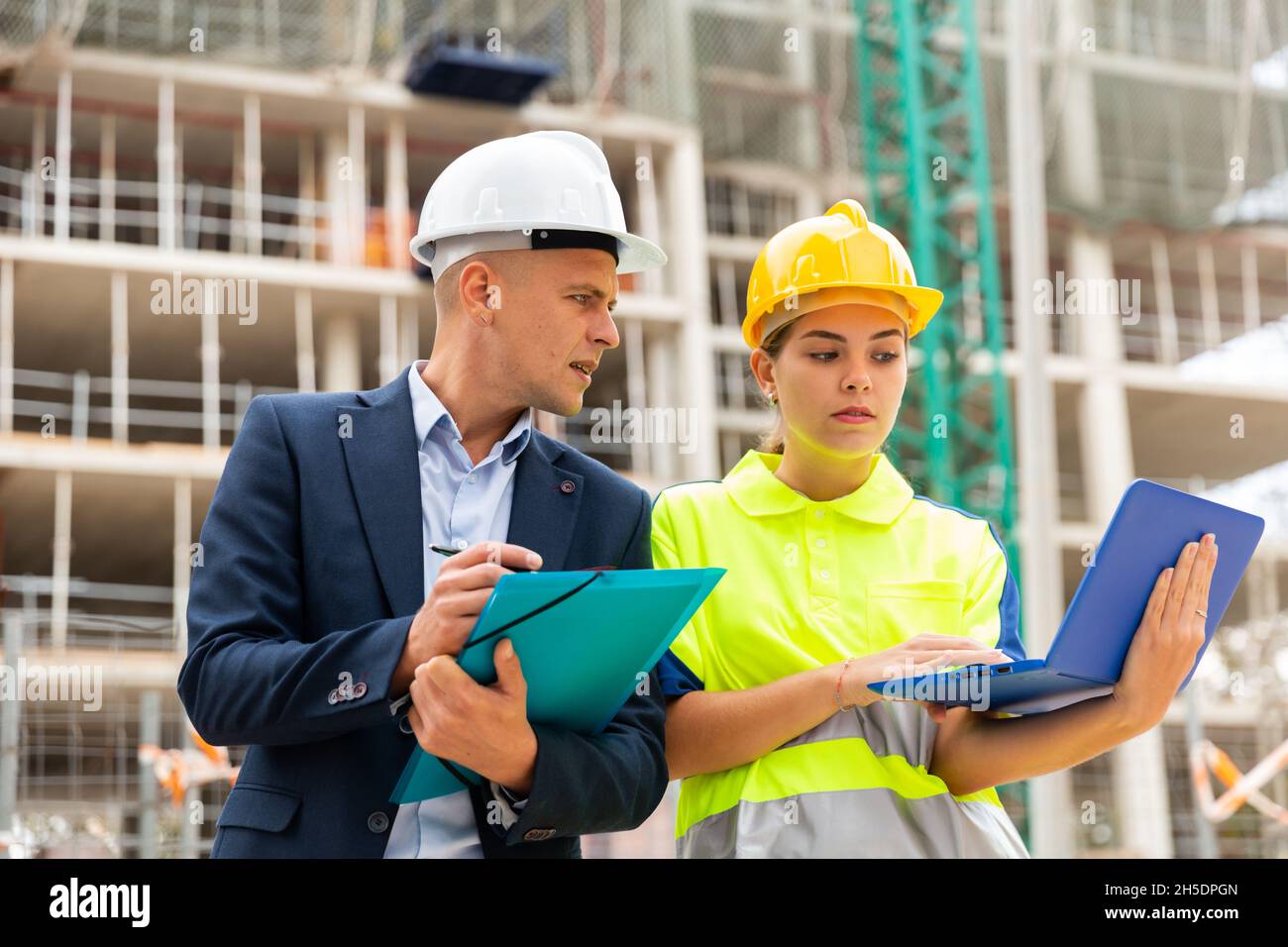 Two architects with laptop discussing construction plan Stock Photo - Alamy