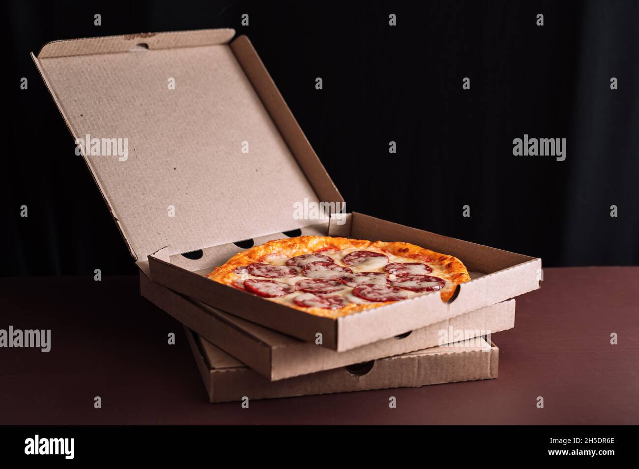 An open box of pizza standing on top of other boxes Stock Photo - Alamy
